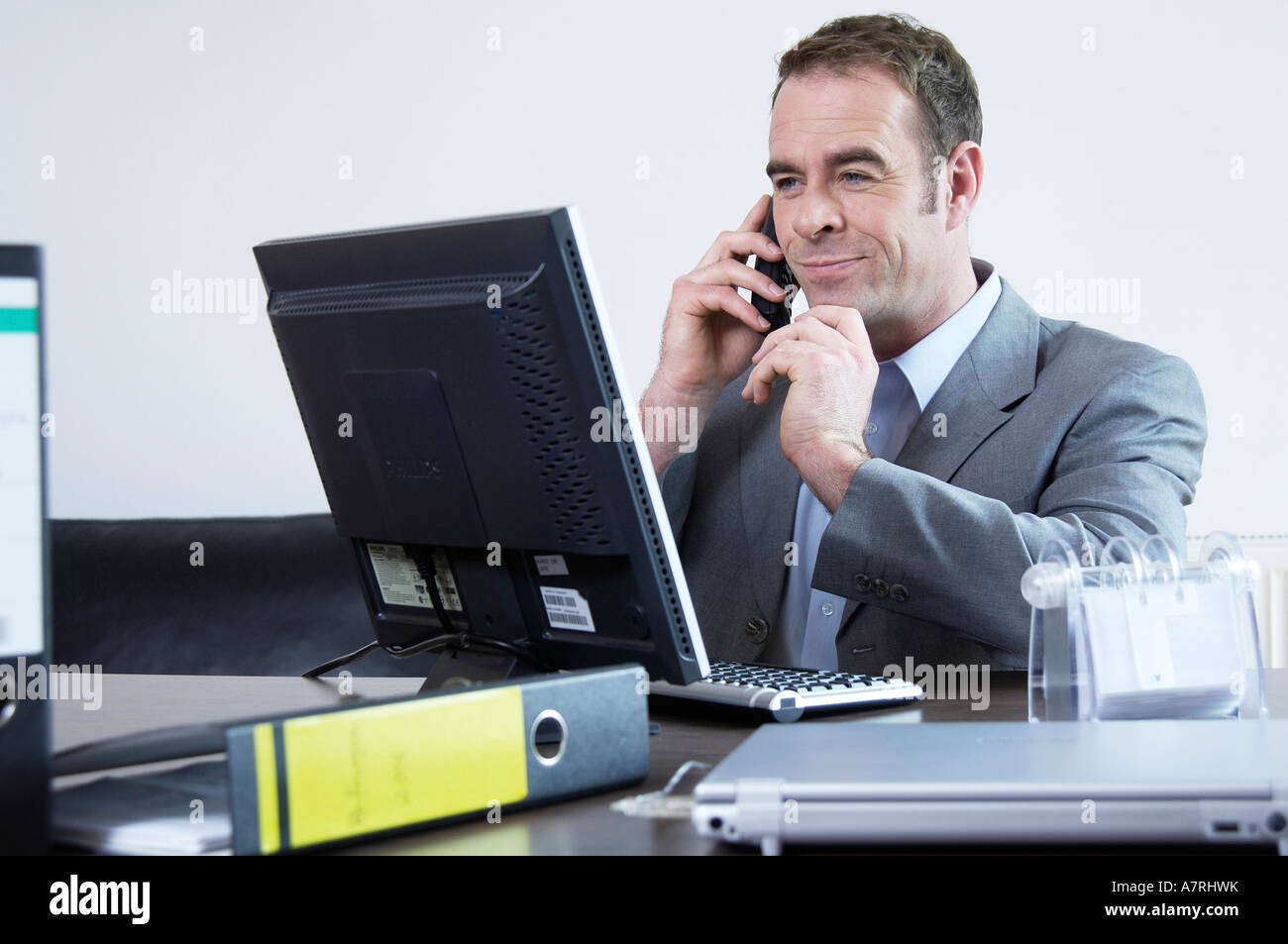 Businessman using computer and mobile phone Stock Photo - Alamy