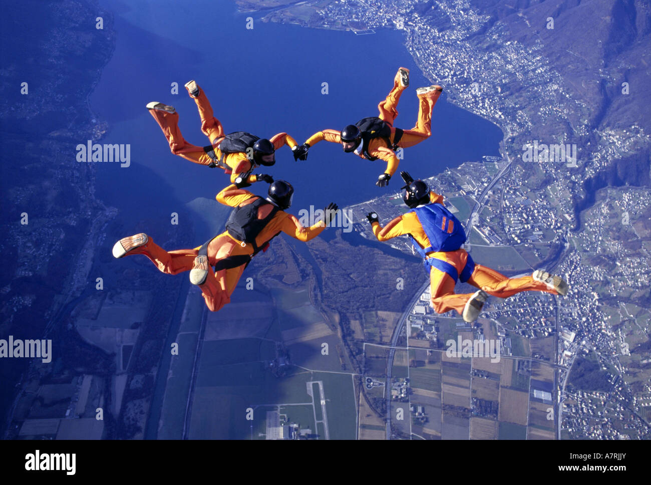 Four people parachuting in formation Stock Photo - Alamy