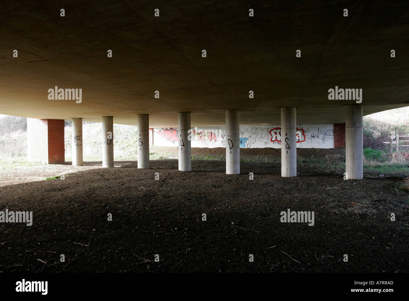 Subway under the road with graffiti and muddy hand prints on supporting ...