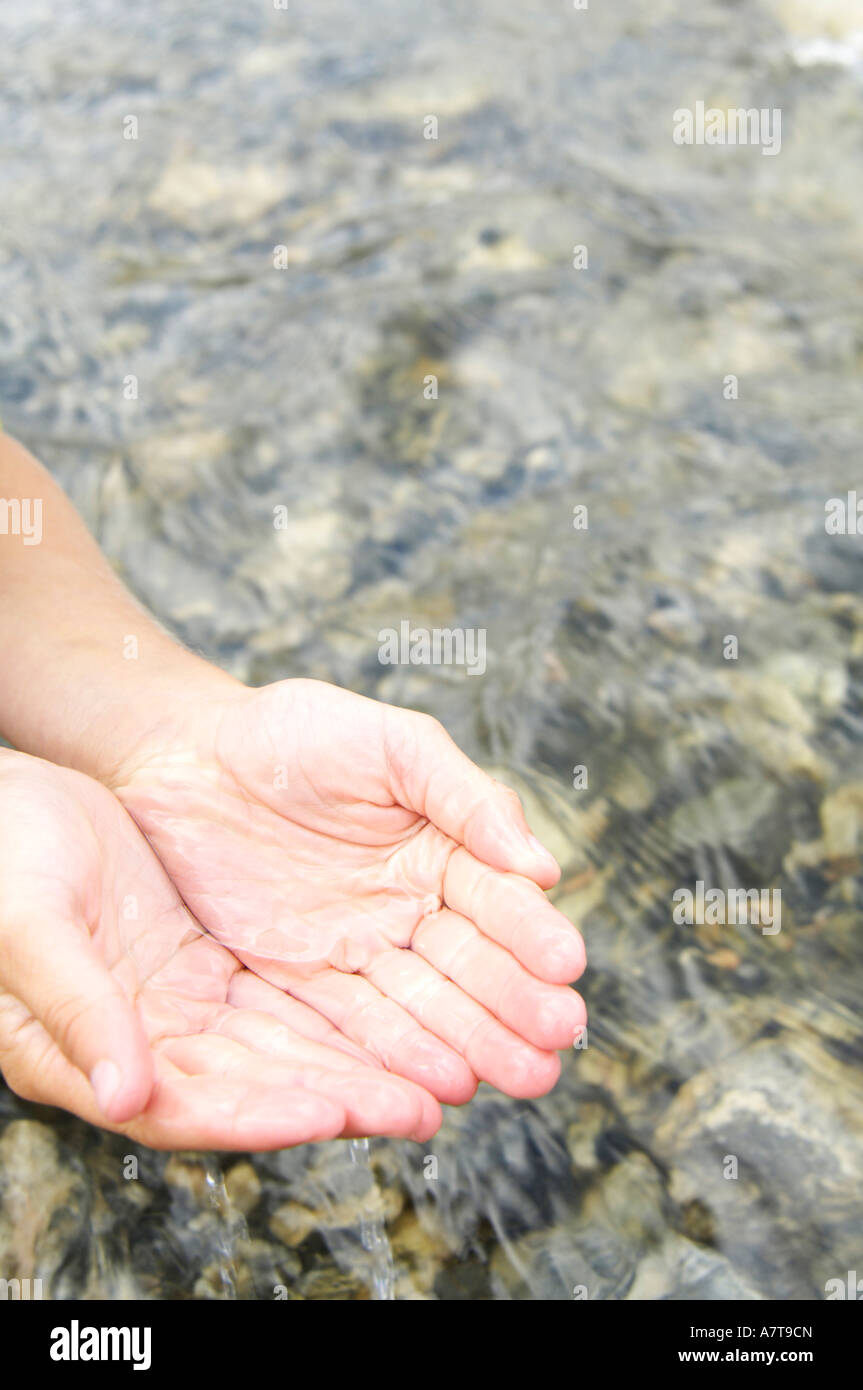 Hands cupping water over stream Stock Photo - Alamy