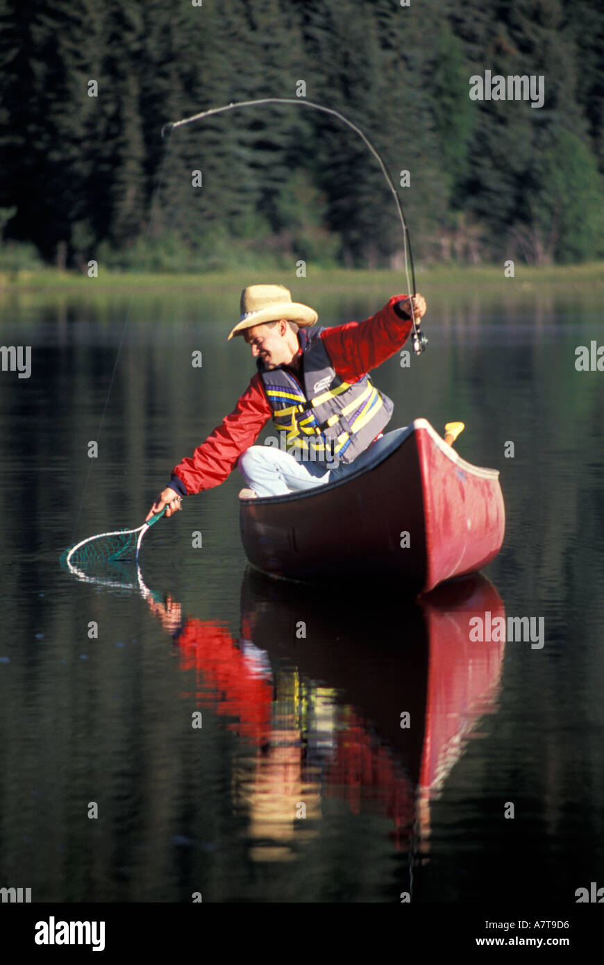 Man Catching a Fish in a Canoe Stock Photo - Alamy