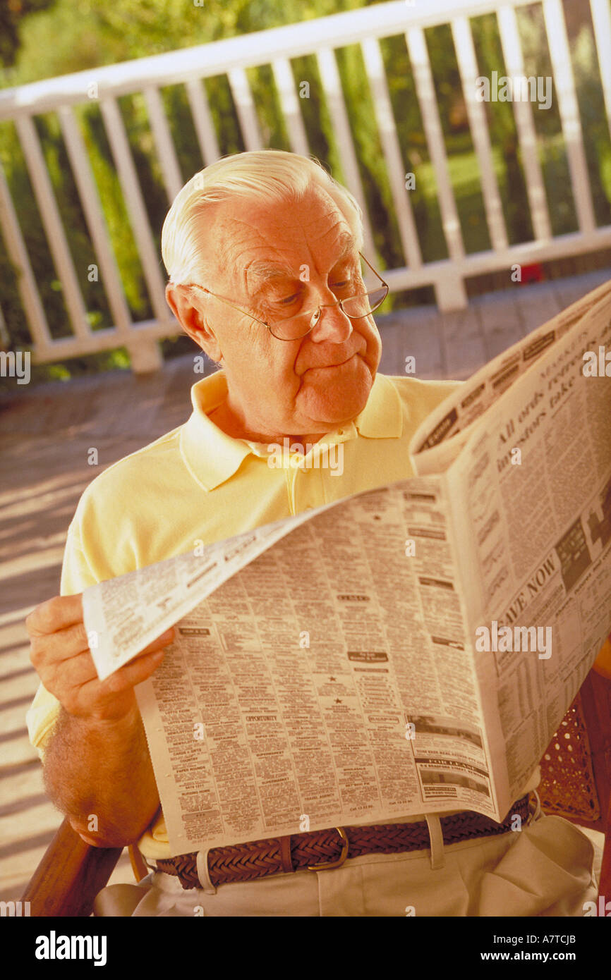 portrait of elderly man sitting on a porch reading a newspaper Stock ...