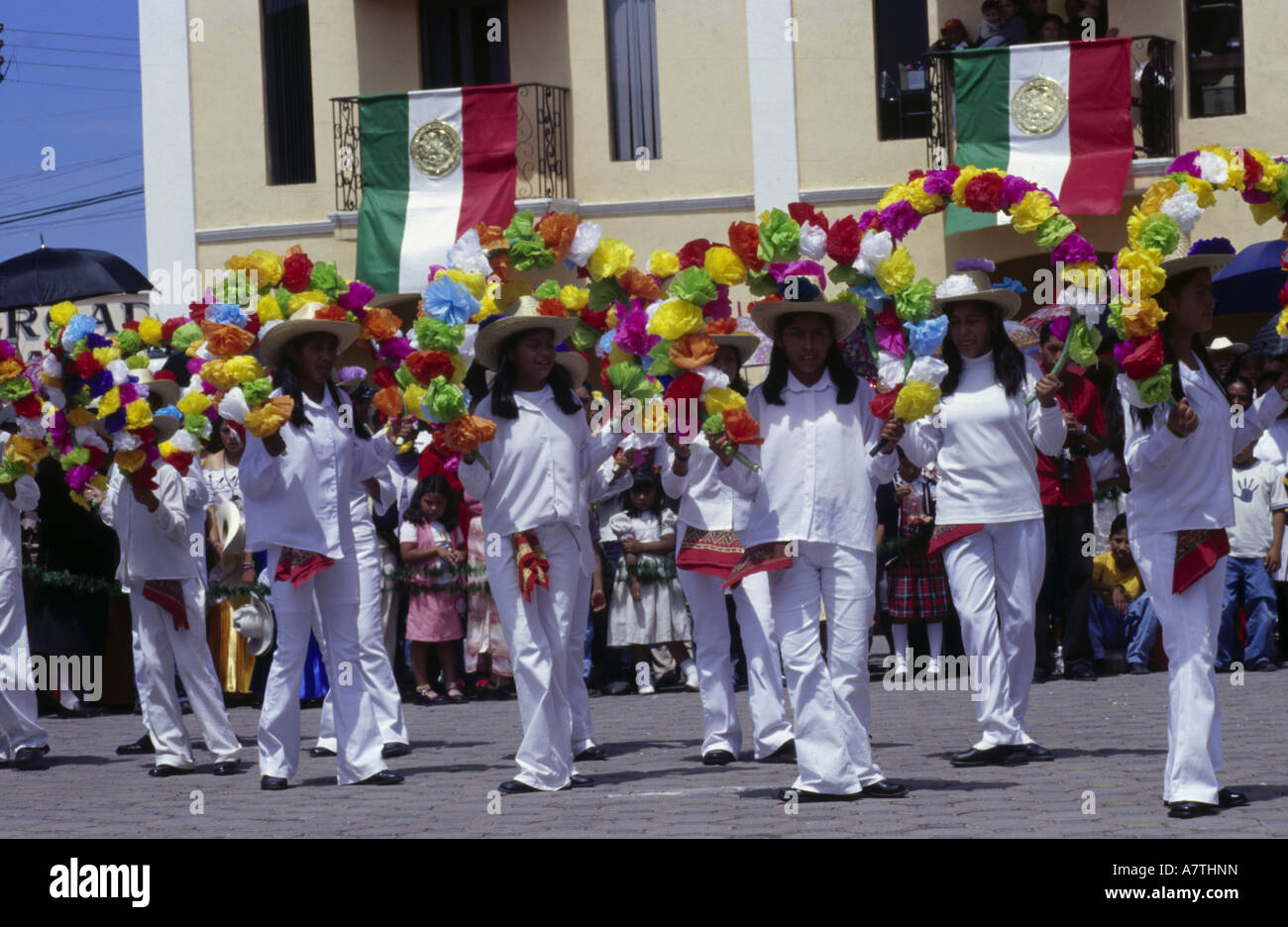 Women carrying floral decorations during independence day parade Mexico ...
