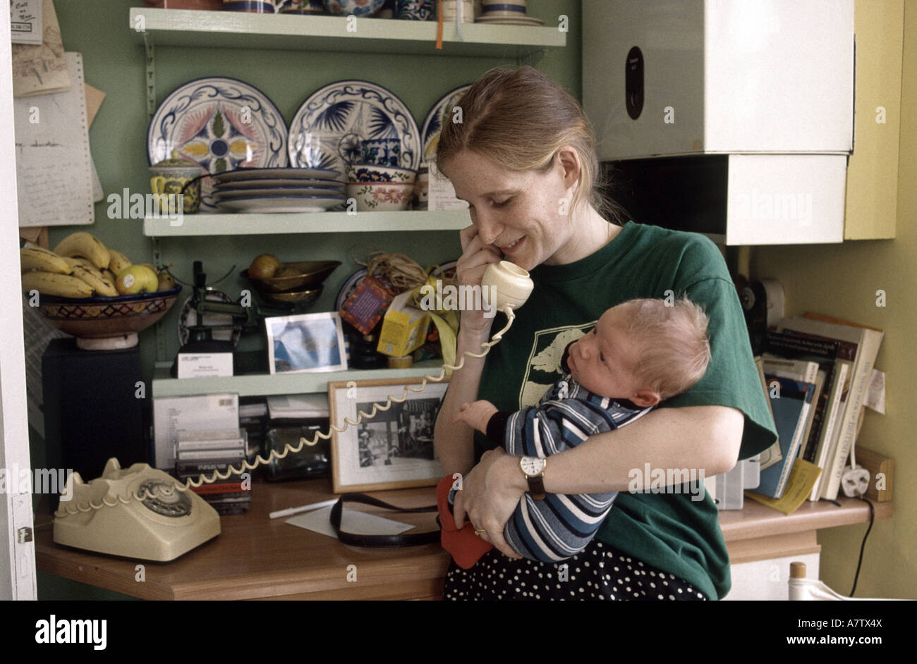 mother on the phone holding a crying baby Stock Photo - Alamy