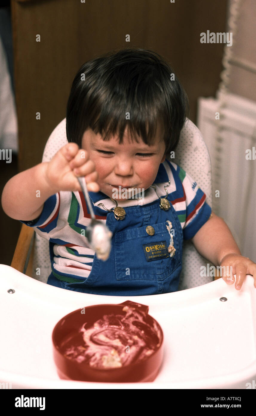 Nine month toddler having difficulty eating his food Stock Photo - Alamy