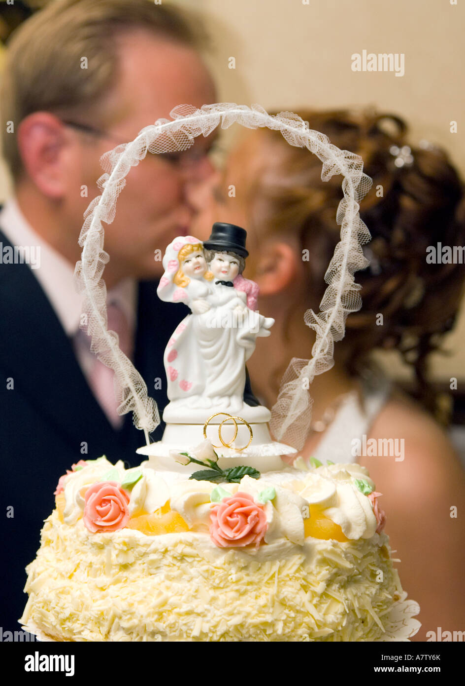 wedding cake with the newlyweds behind blurred Stock Photo - Alamy