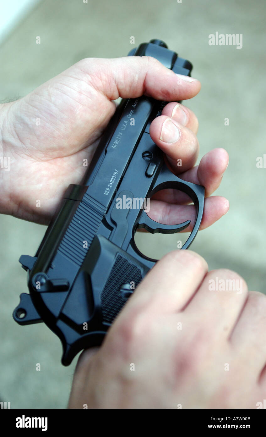 a man holding an automatic pistol beretta gun Stock Photo - Alamy