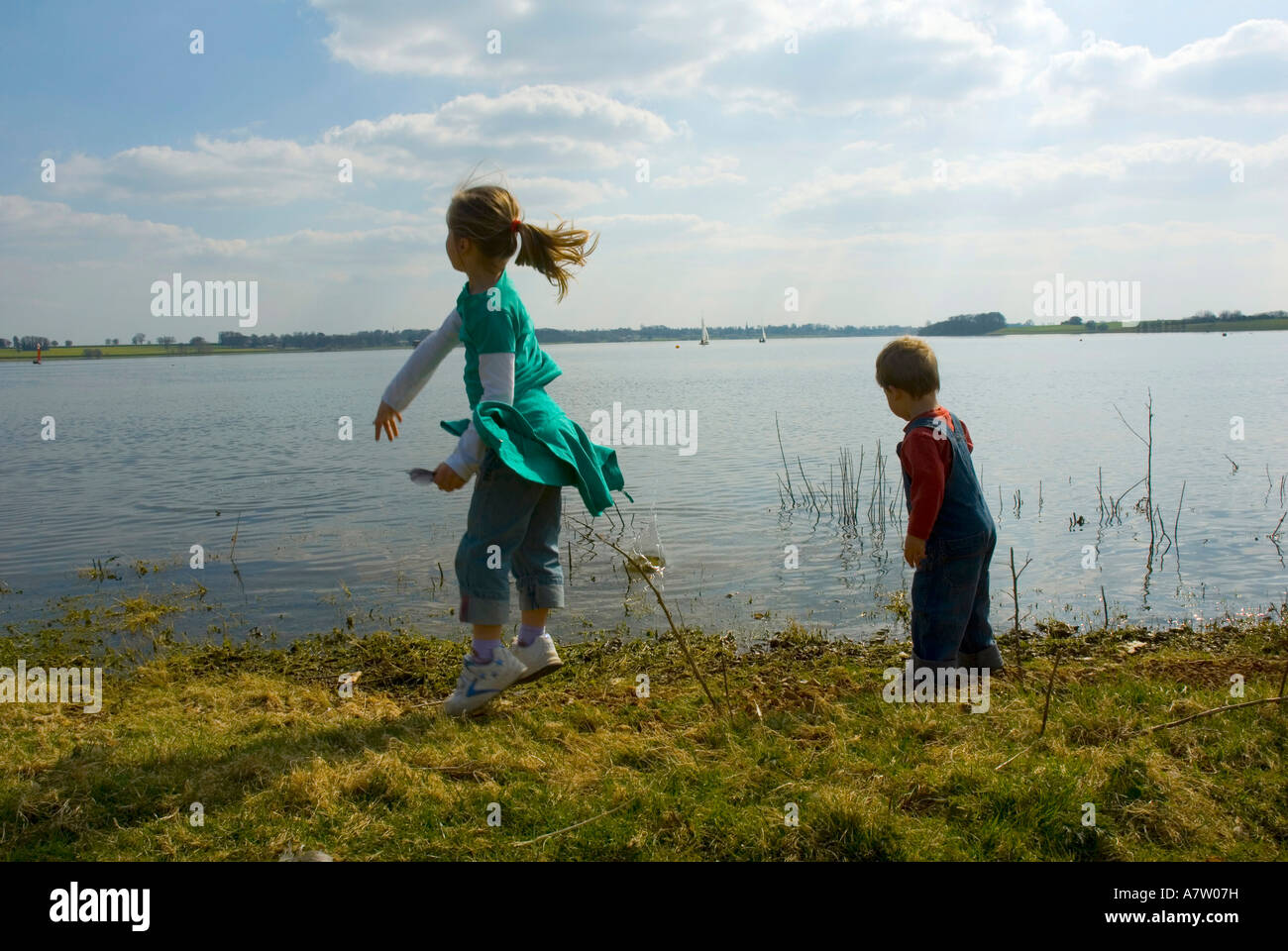 A Young girl throwing stone into Rutland Water Stock Photo - Alamy