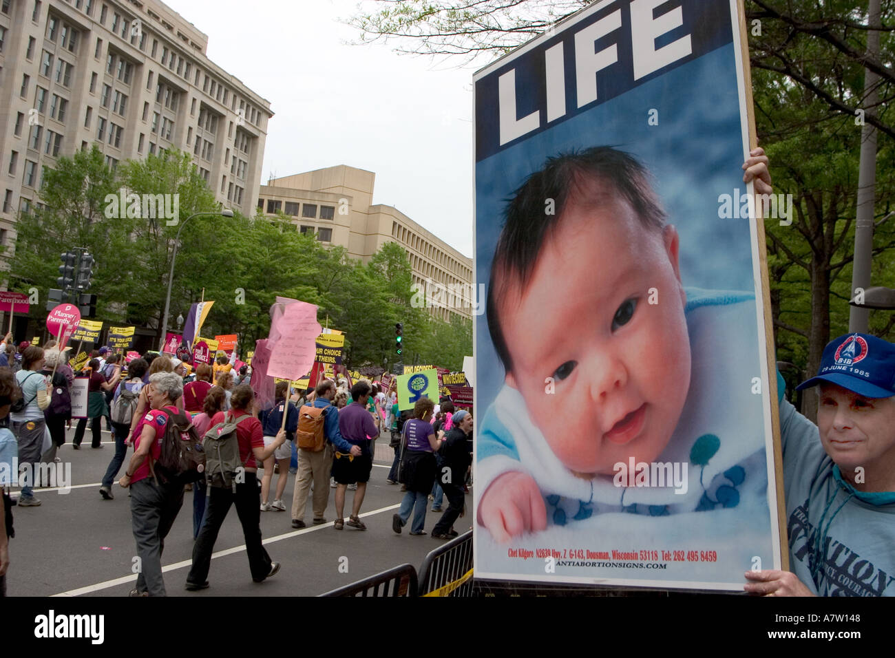 Pro choice protester march past a man holding a pro life placard ...