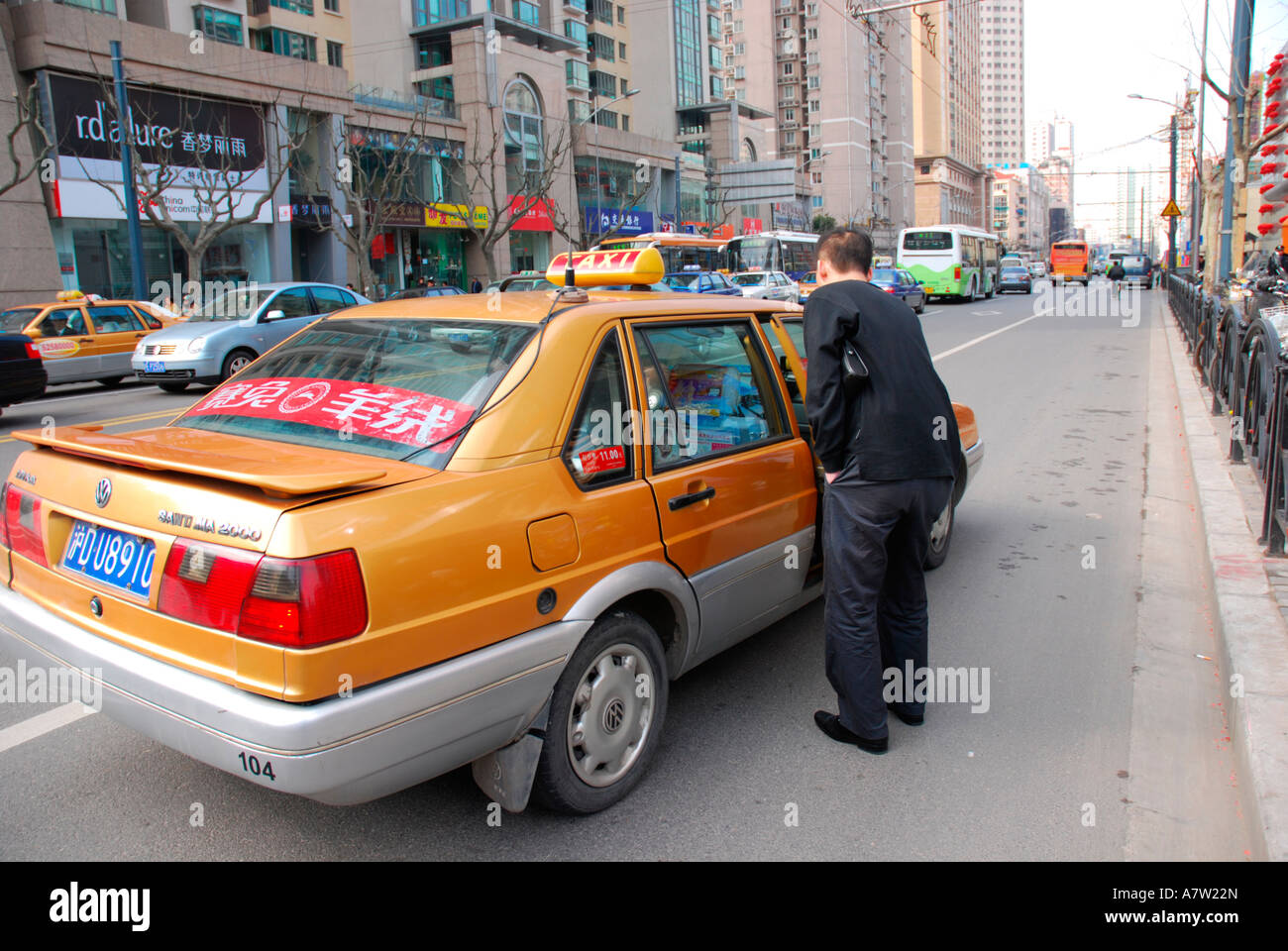 Businessman hailing a cab or taxi in Shanghai China Stock Photo - Alamy