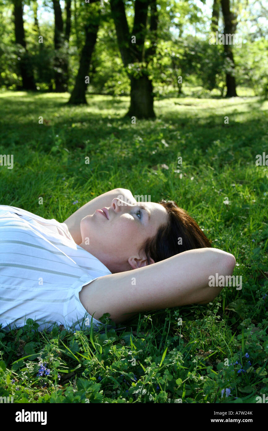 Side profile of young woman lying on grass Stock Photo - Alamy