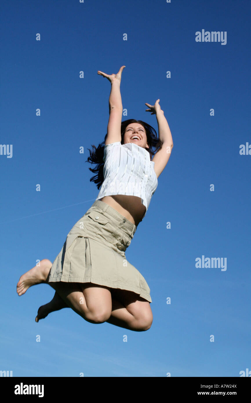 Low angle view of young woman jumping in mid-air Stock Photo - Alamy