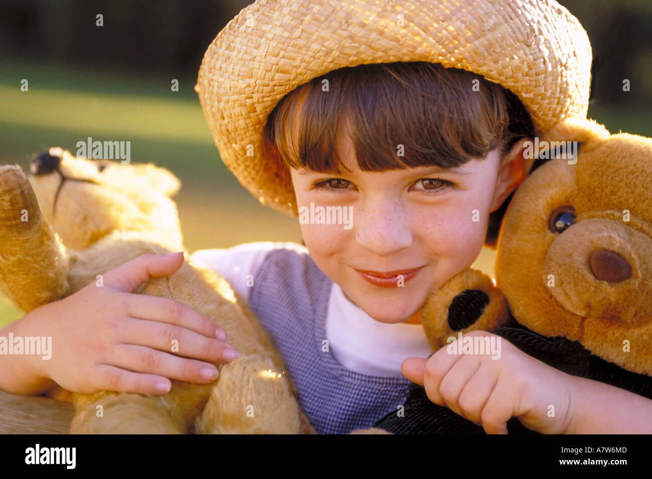 portrait of 8-year-old girl wearing a hat cuddling with teddies Stock ...