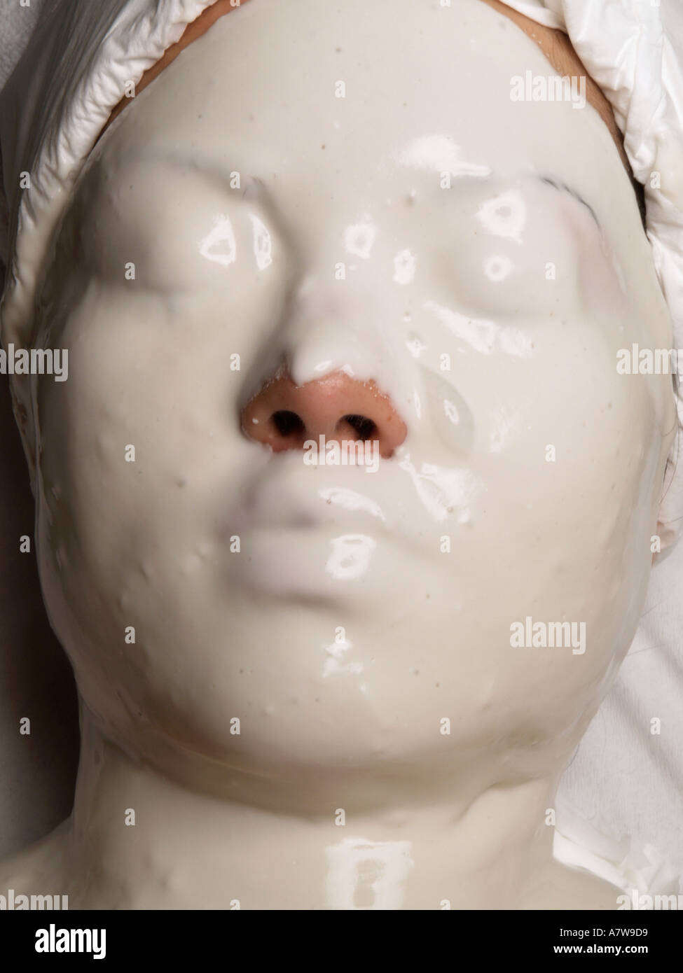 Woman wearing a rubber fluid face mask during a beauty salon skin ...