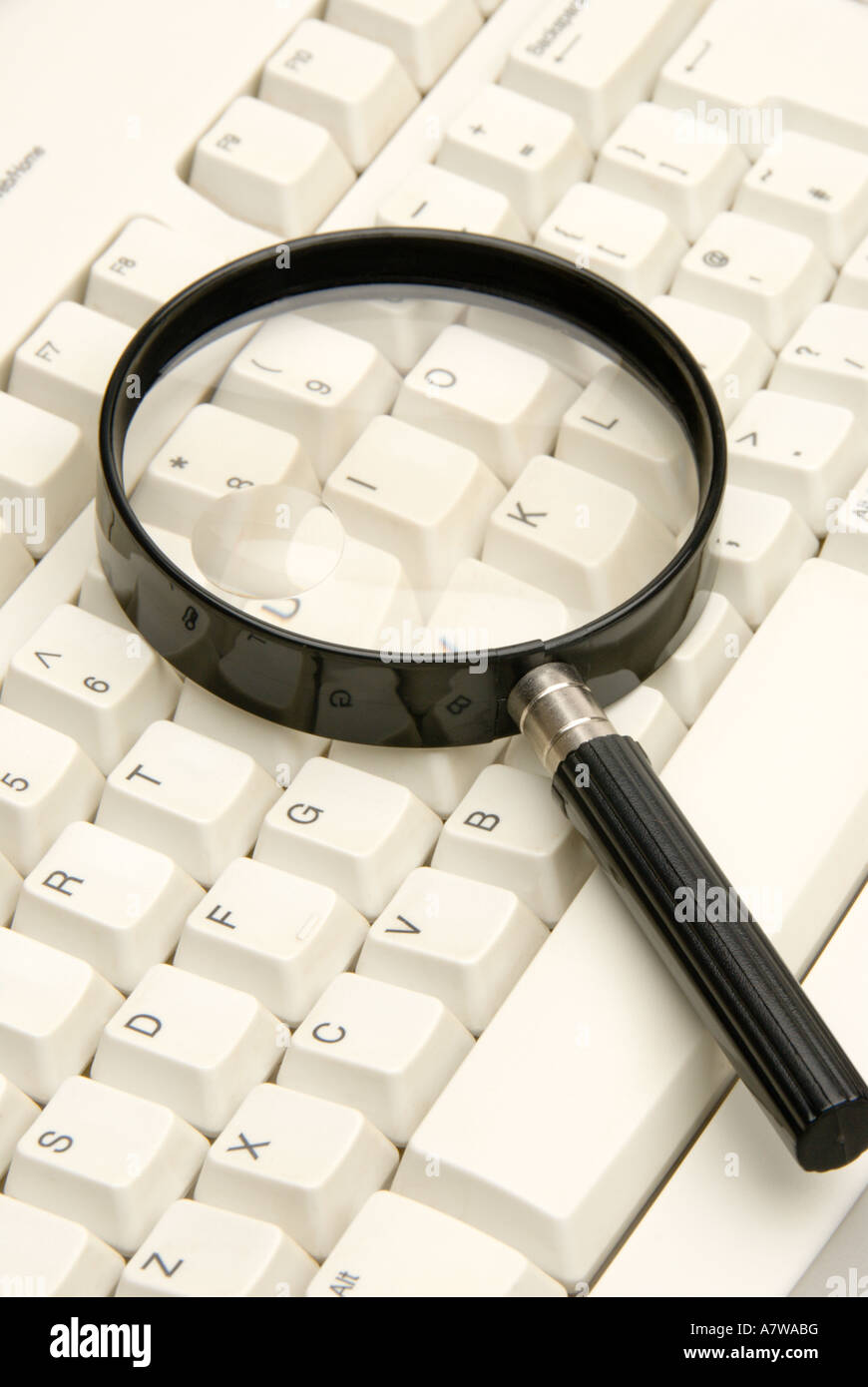Computer keyboard with magnifying glass Conceptual Stock Photo - Alamy