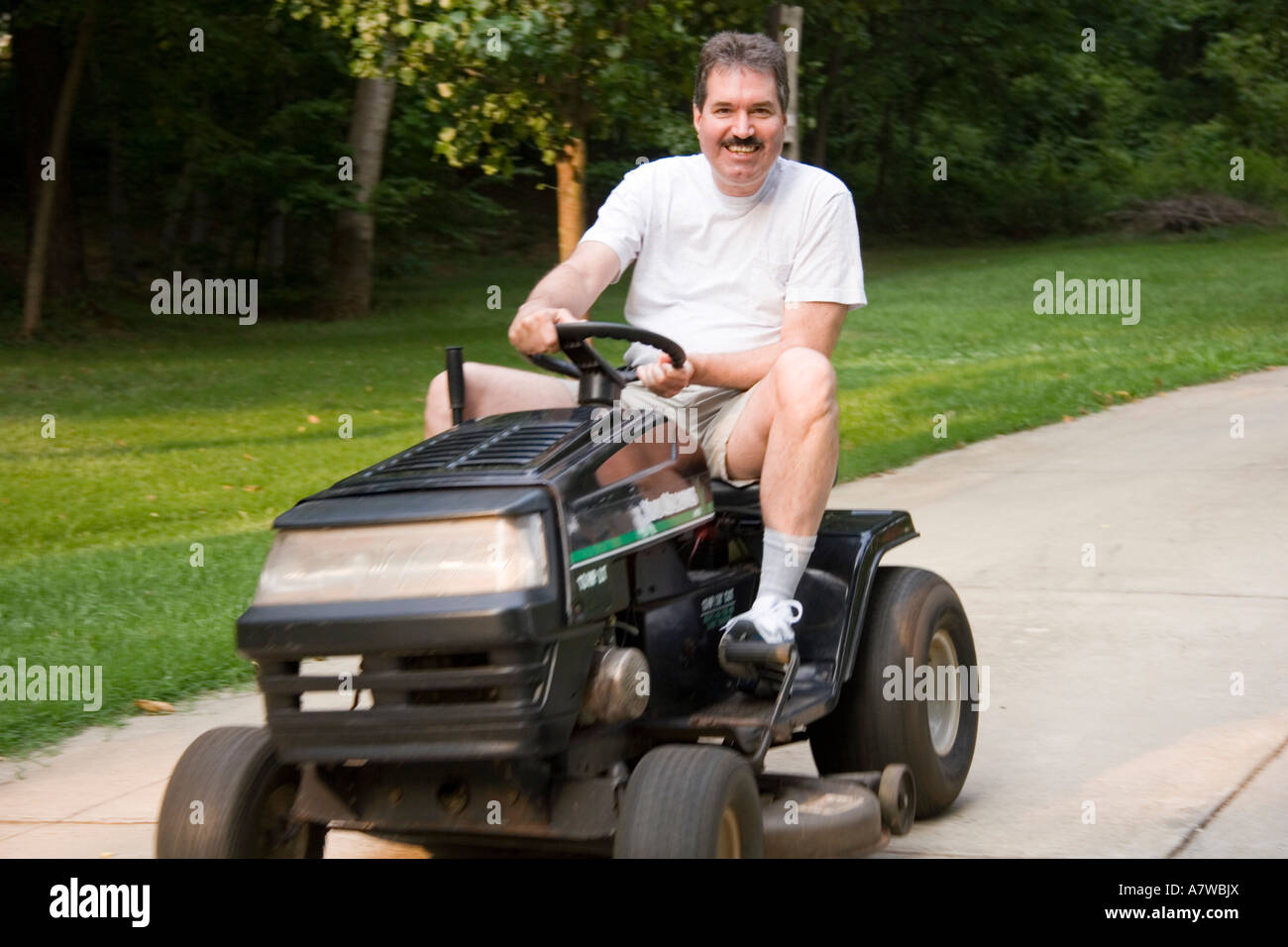 Man sitting on lawn mower hi-res stock photography and images - Alamy