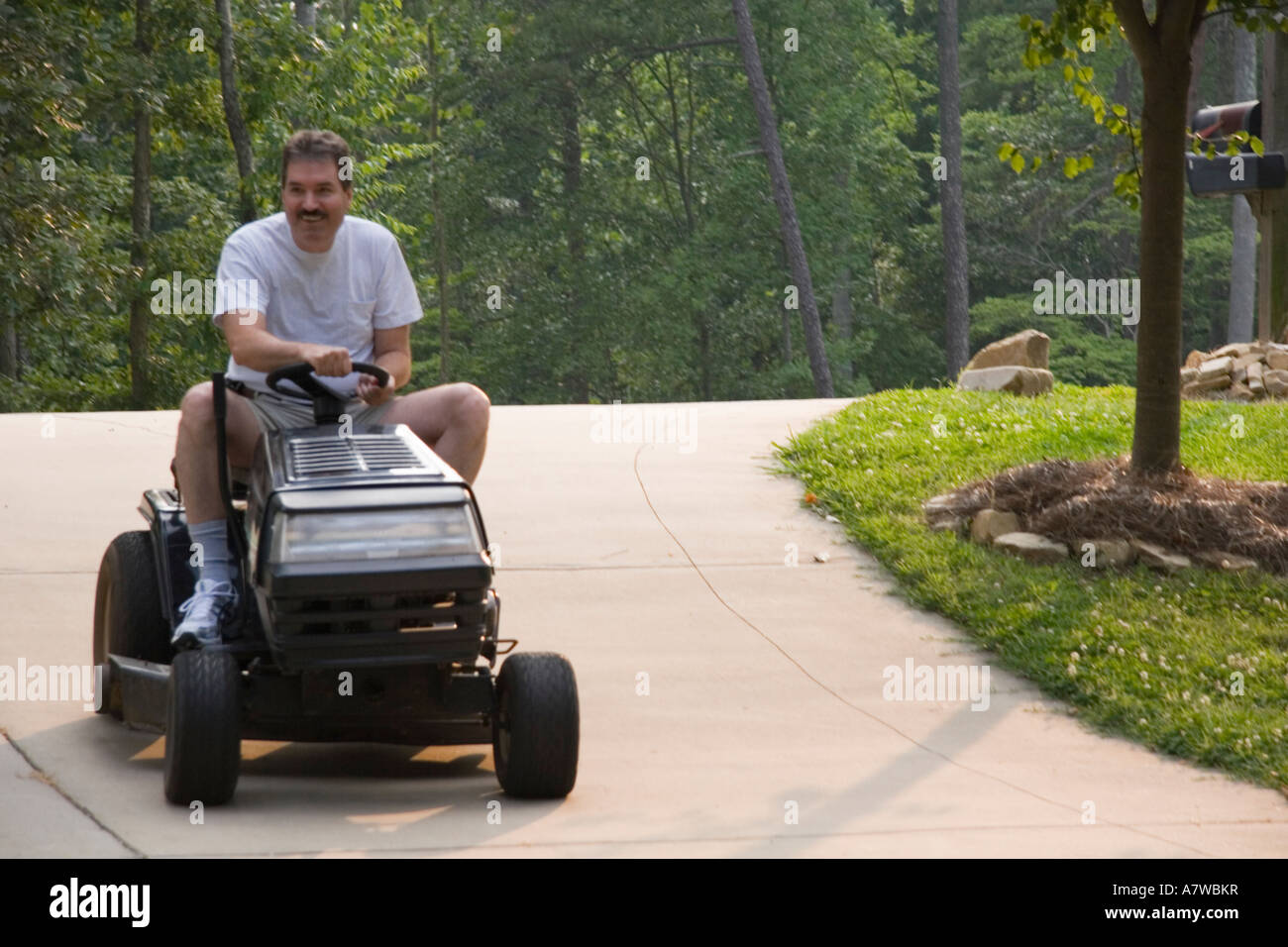 Man sitting on lawn mower hi-res stock photography and images - Alamy