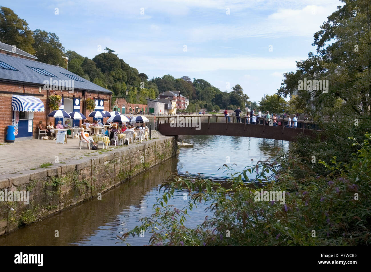 People sit in the sun outside a cafe, the Quay, Exeter, Devon, UK Stock ...