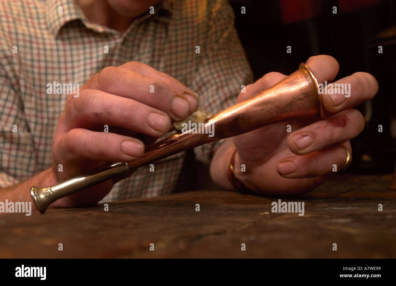 A HUNTSMAN AT THE BEAUFORT HUNT IN WILTSHIRE POLISHING HIS HUNTING HORN ...
