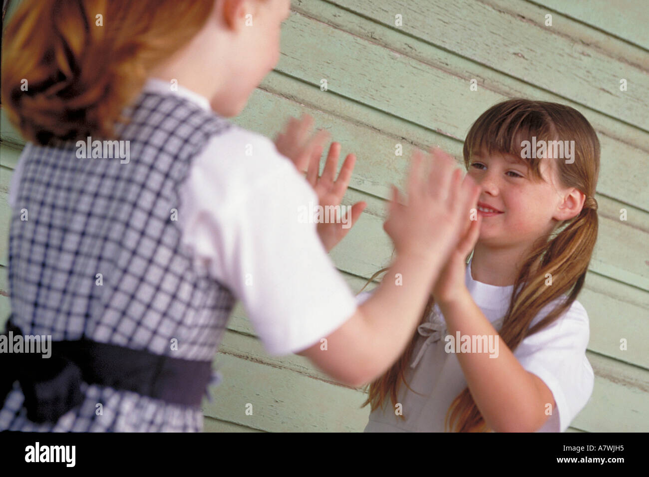 portrait of two girls clapping hands Stock Photo - Alamy