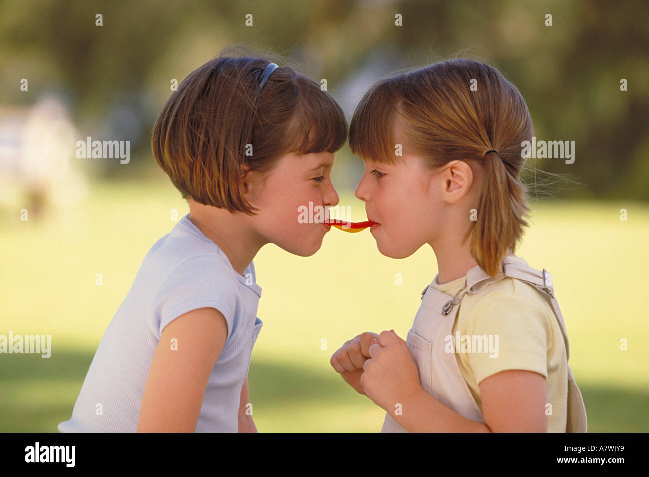 portrait of two girls eating sweets Stock Photo - Alamy