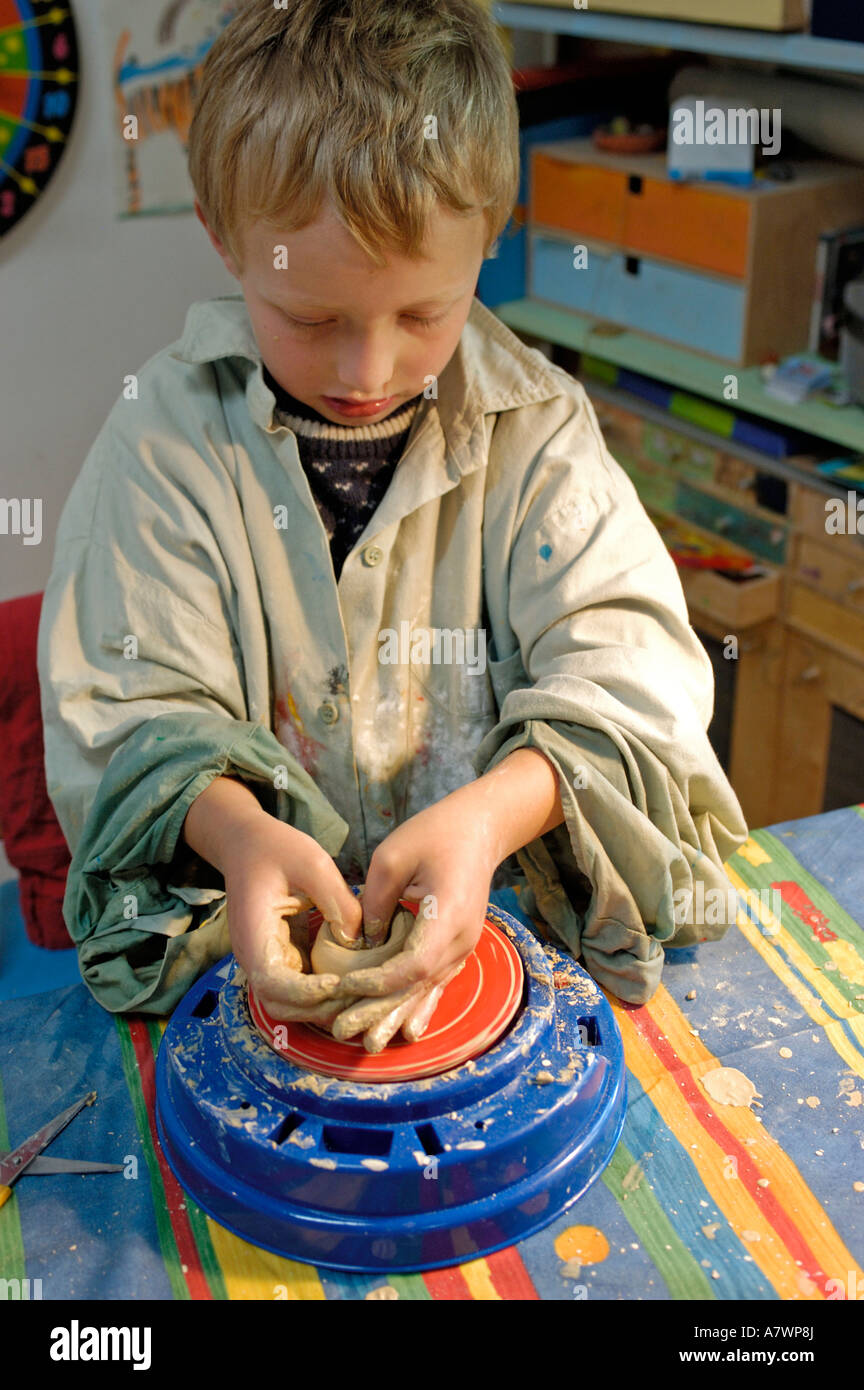 Young boy making pottery with a potter's wheel Stock Photo - Alamy