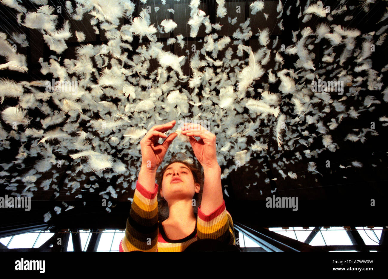 Girl making a cape of feathers for an artwork installation Stock Photo ...