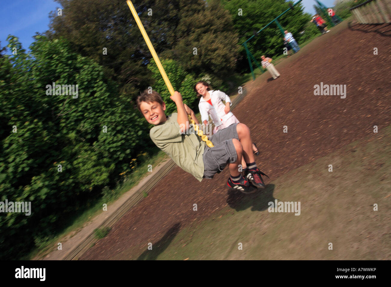 Children brother and sister playing together on aerial slide in ...