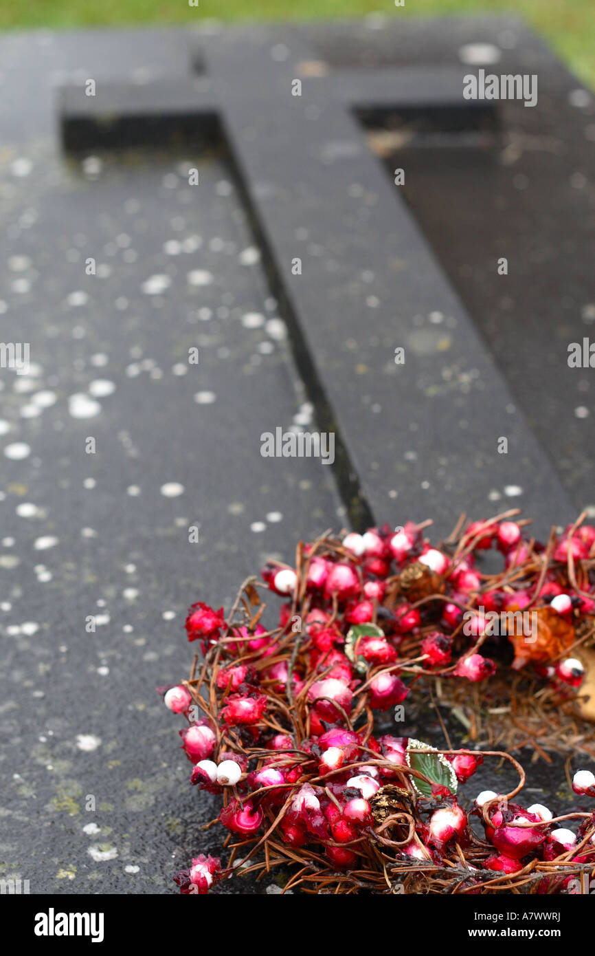Cemetery grave with large cross and red flower wreath Stock Photo - Alamy