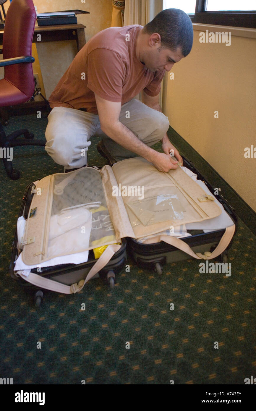 man packing suitcase on floor Stock Photo - Alamy