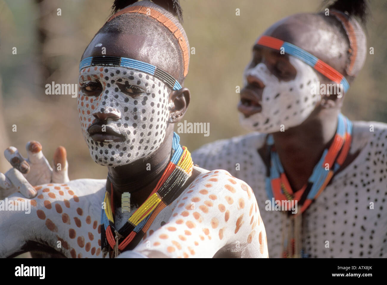 A Karo warrior puts body paint on another man near their village in ...