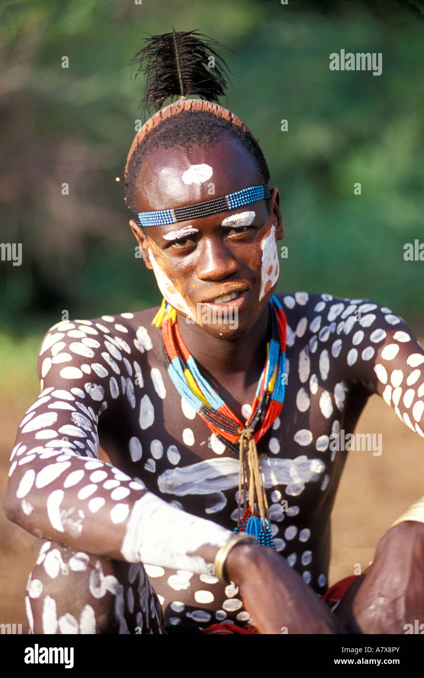 A Karo warrior sits in a clearing, wearing body paint, in Ethiopia's ...