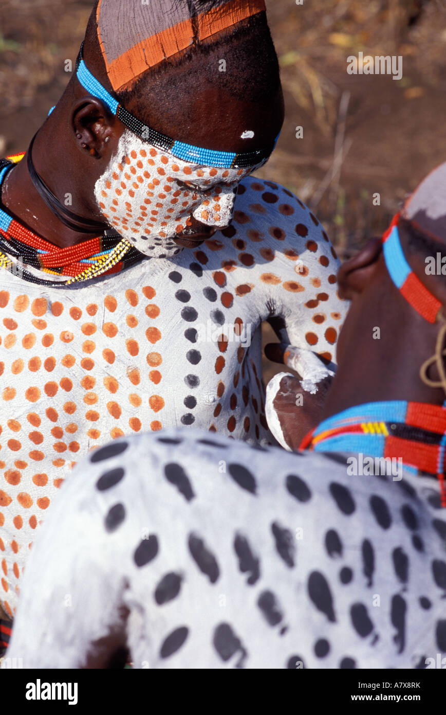 A Karo warrior puts body paint on another Karo man, in Ethiopia's Omo ...