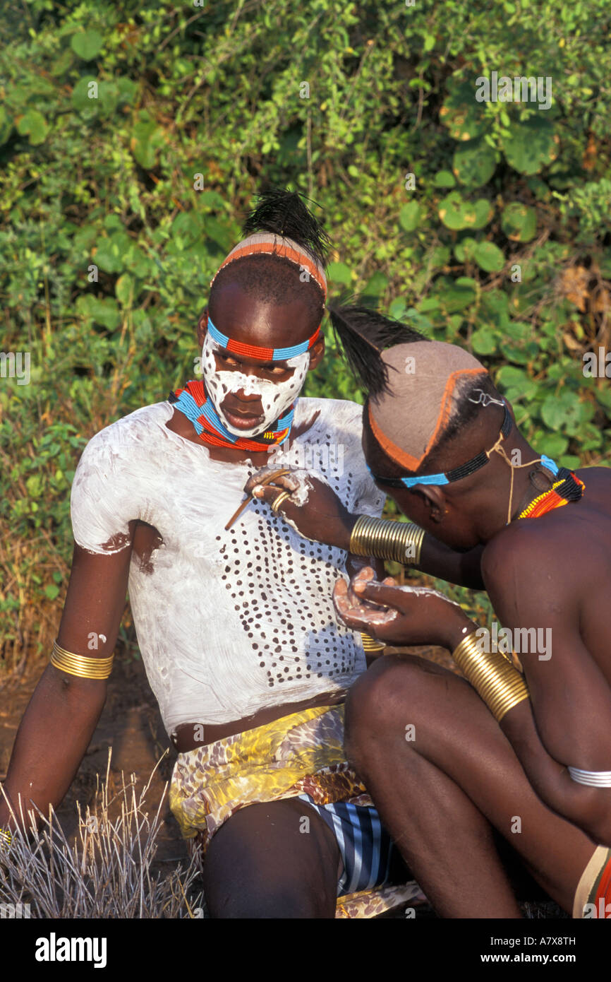 A Karo warrior puts body paint on another Karo man, in Ethiopia's Omo ...