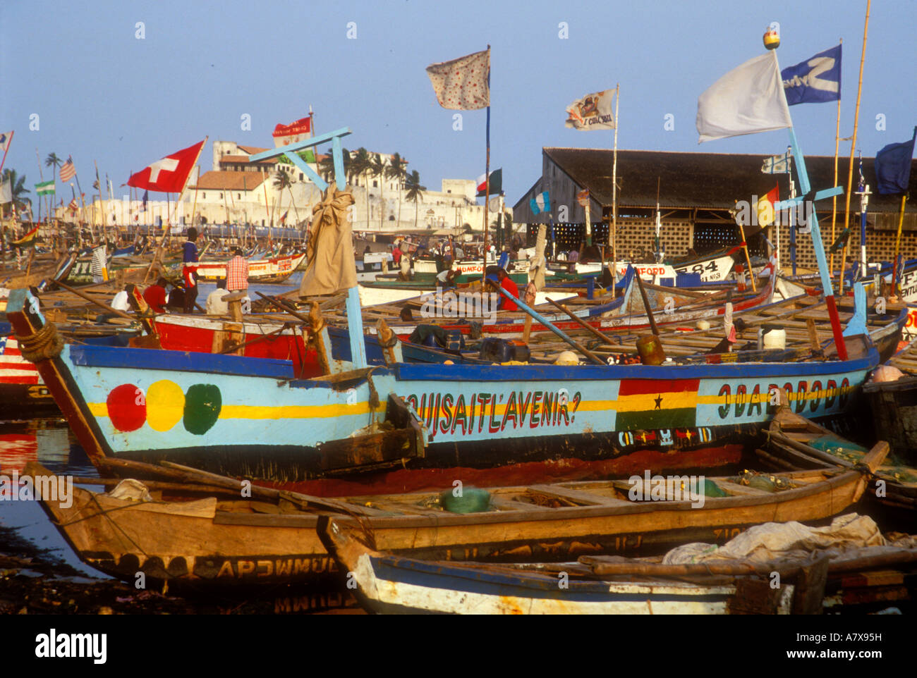 Ghana: Elmina, fishing port, colorful hand painted boats, various flags ...