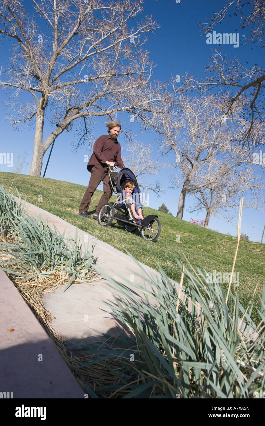 man pushing toddler son in jogging stroller outside Stock Photo - Alamy
