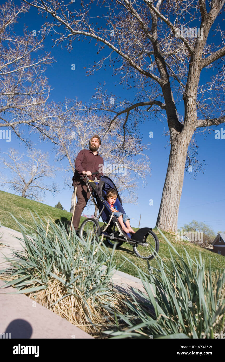 dad pushing child in stroller Stock Photo - Alamy