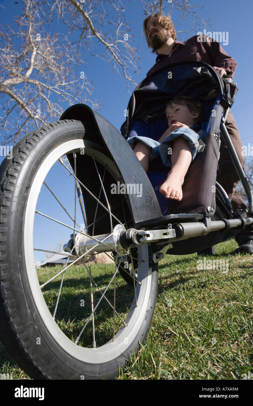 father pushing son in stroller outdoors Stock Photo - Alamy