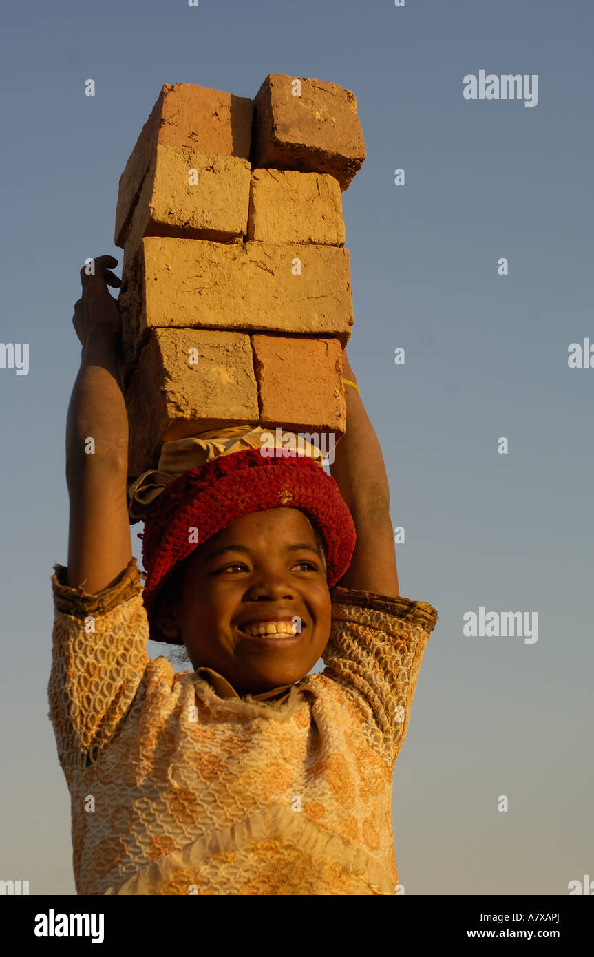 Child carrying bricks. In areas of Madagascar where the soil is ...