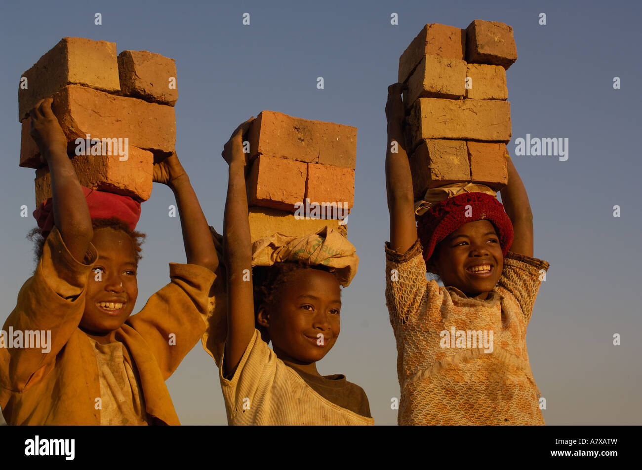 Child carrying bricks. In areas of Madagascar where the soil is ...