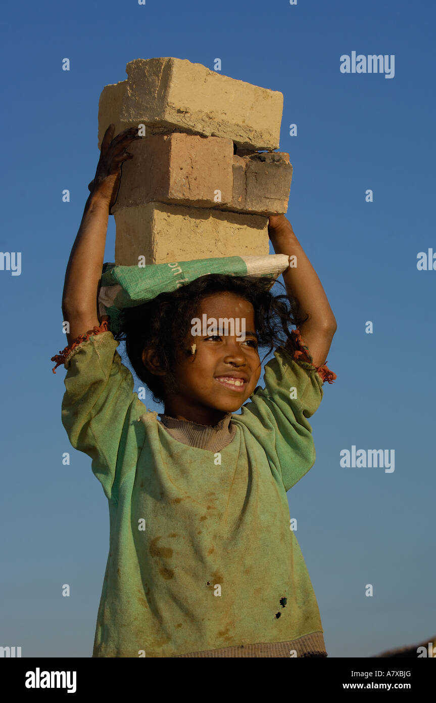 Child carrying bricks. In areas of Madagascar where the soil is ...