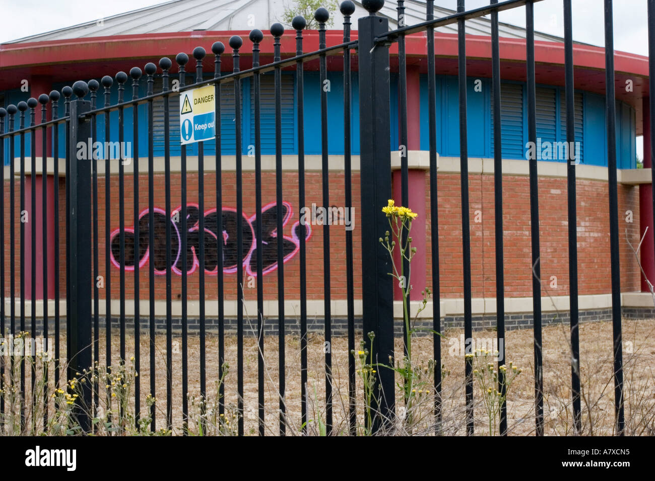 Round water utility station building tagged by graffiti and behind iron ...