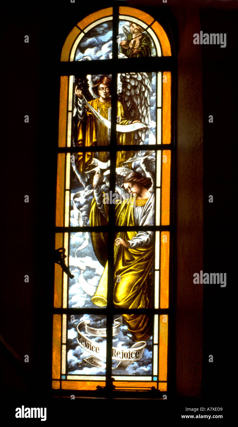Angels holding a scroll and playing trumpet and violin in stained glass ...