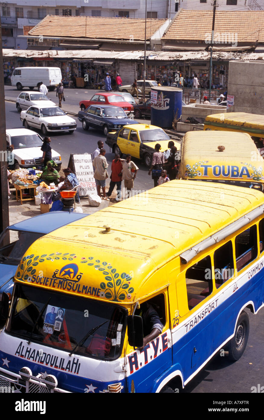 Brightly-colored buses make their way through the crowded streets of ...