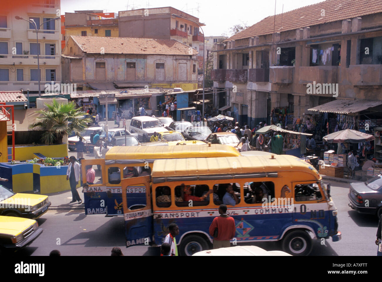 Brightly-colored buses make their way through the crowded streets of ...