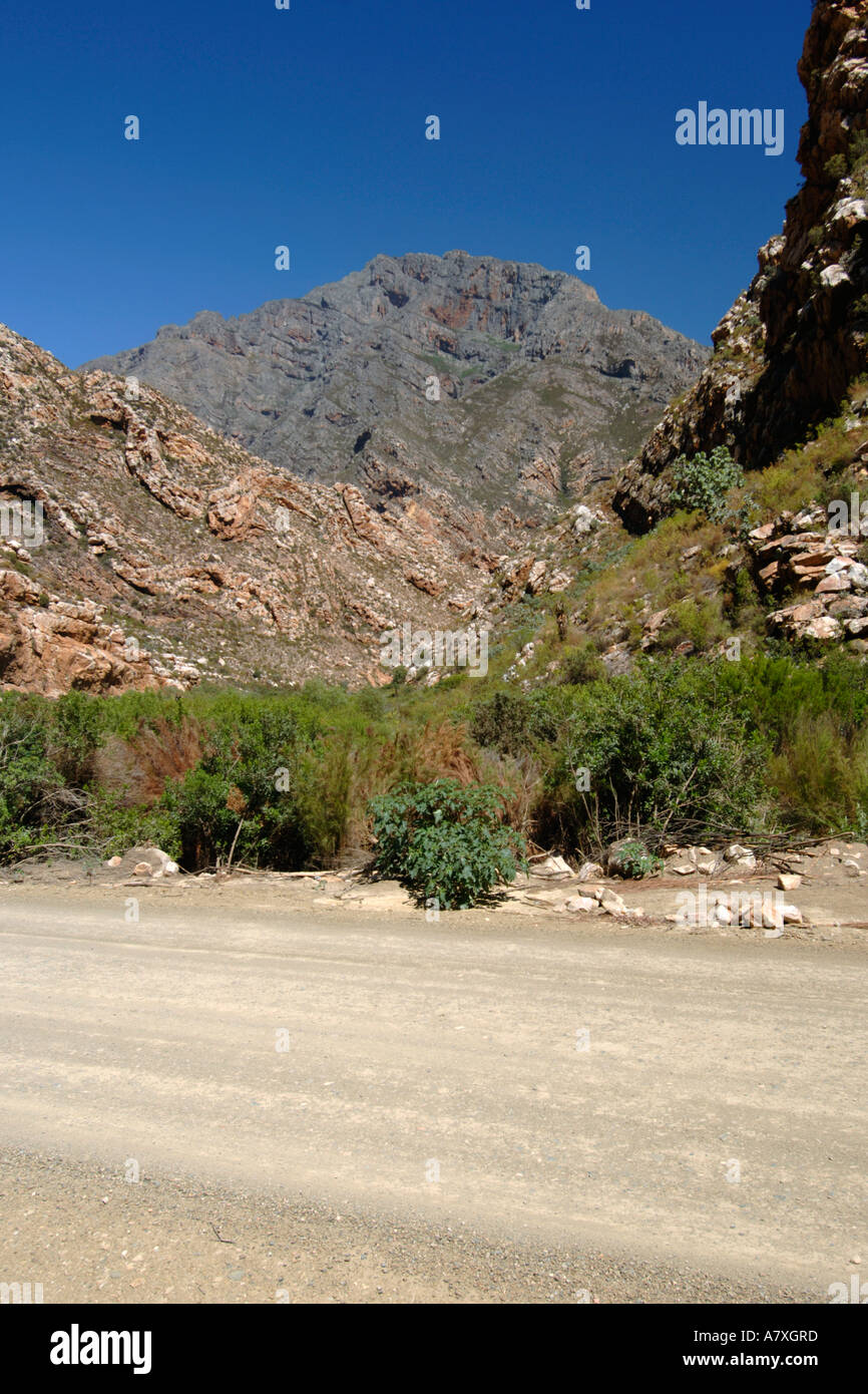 A gravel road leading through the Groot Swartberge mountain range in ...