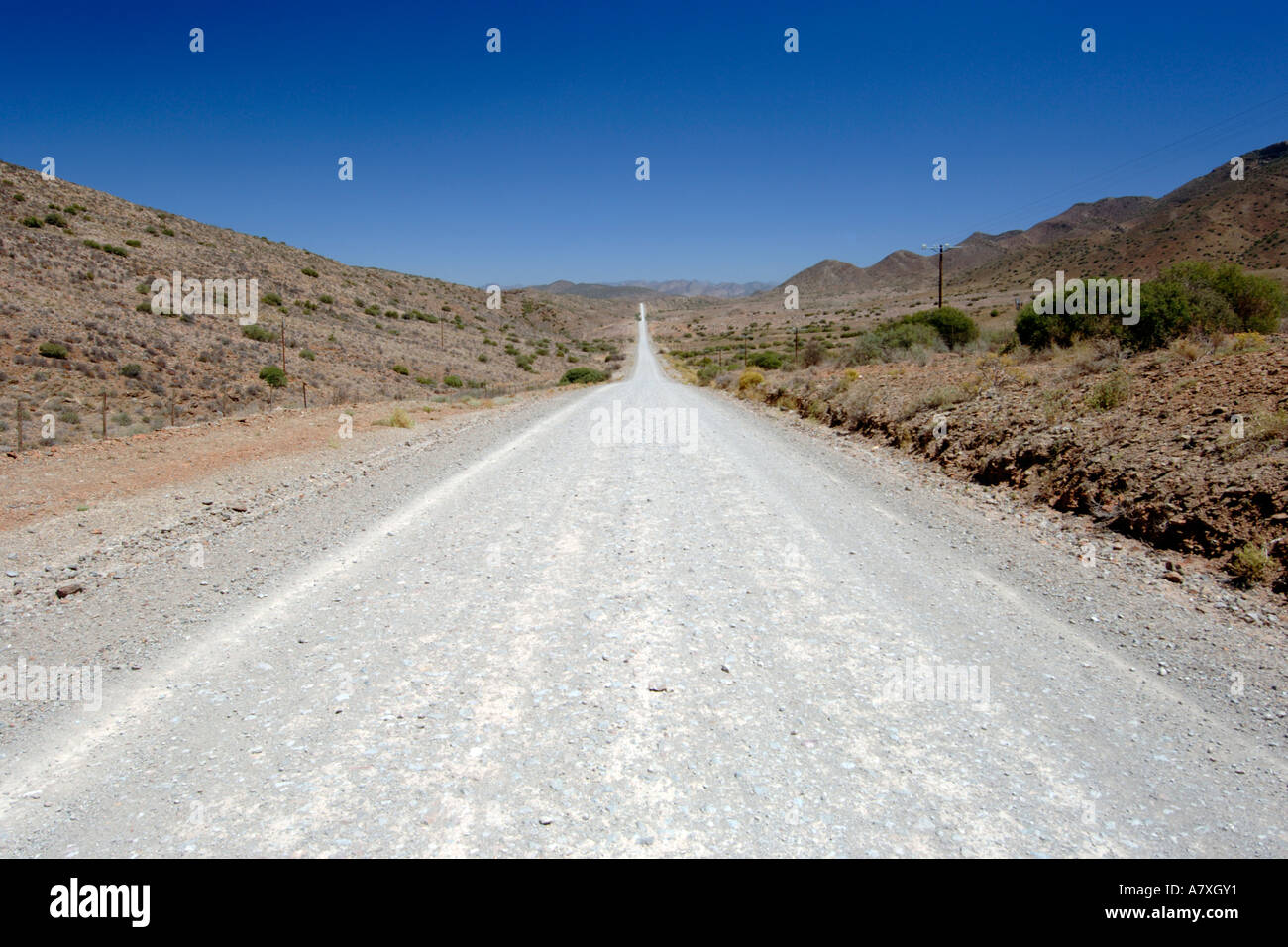 A gravel road leading through the Groot Swartberge mountain range in ...