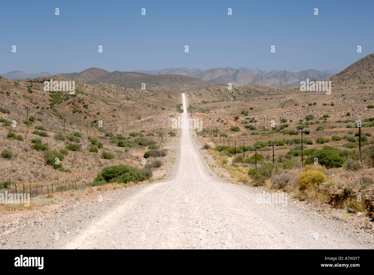 A gravel road leading through the Groot Swartberge mountain range in ...