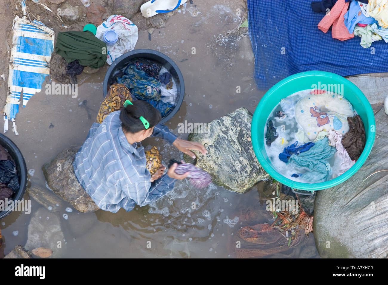 Asia, Burma-Myanmar, Woman washing clothing on the edge of Salween ...