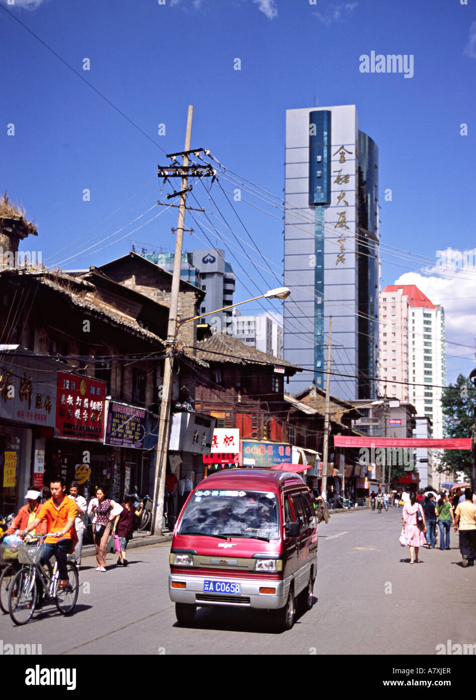 Asia, China, Kunming. Modern hi-rise buildings tower over old town ...
